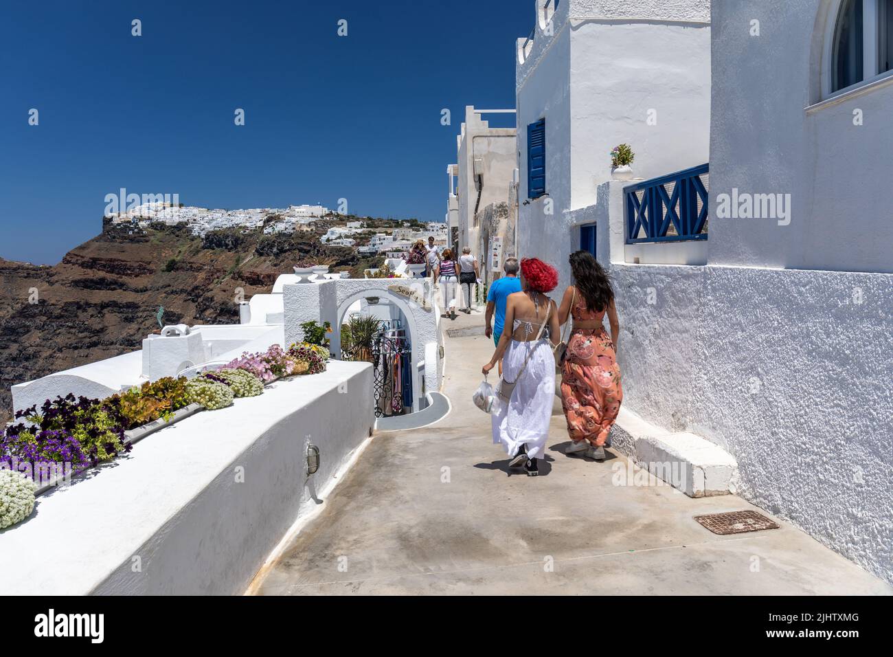 Tourist walking the caldera pathway in Fira, Santorini, Cyclades ...