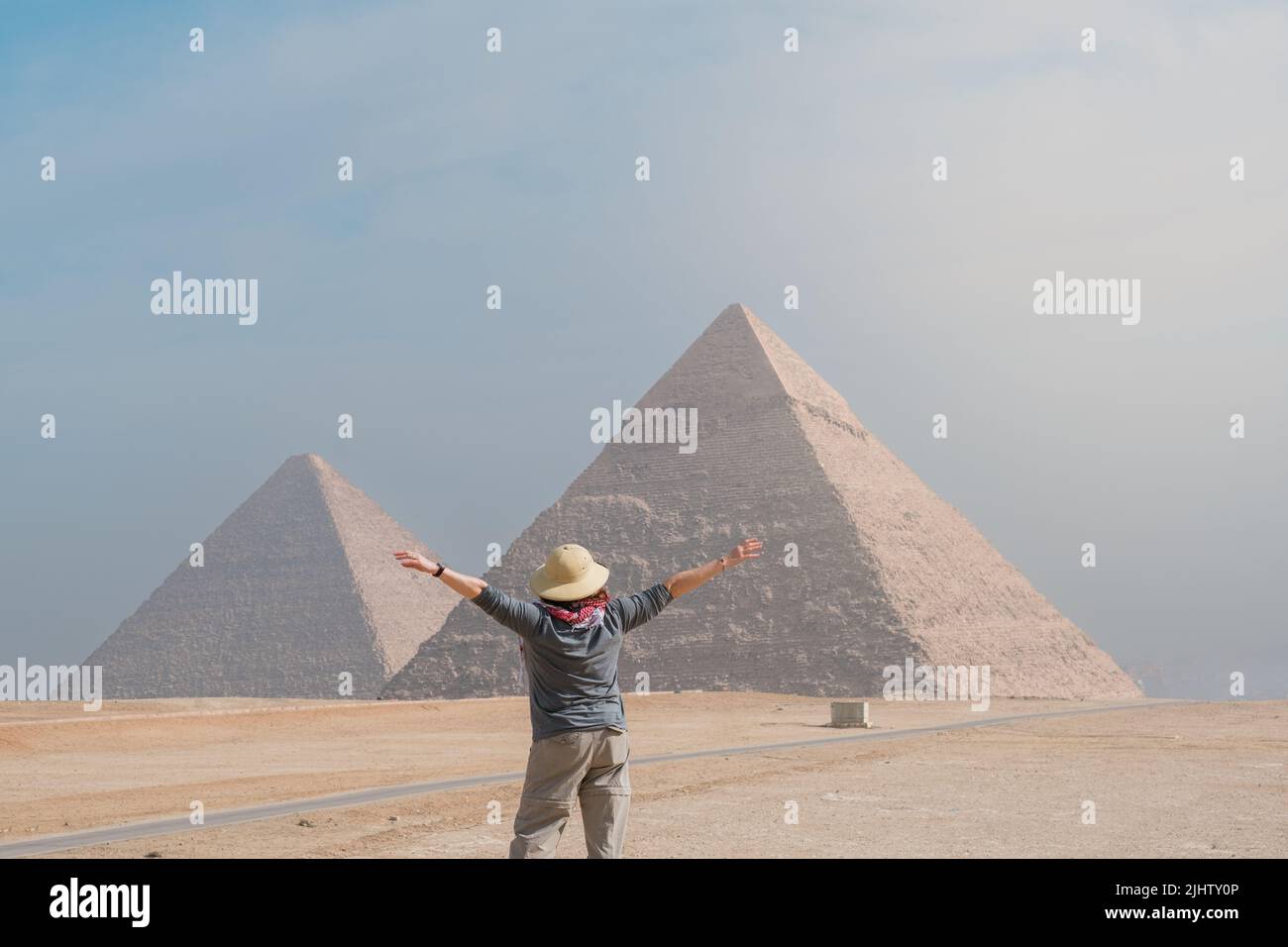 back view of tourist woman standing in front of pyramids. Egypt, Cairo ...