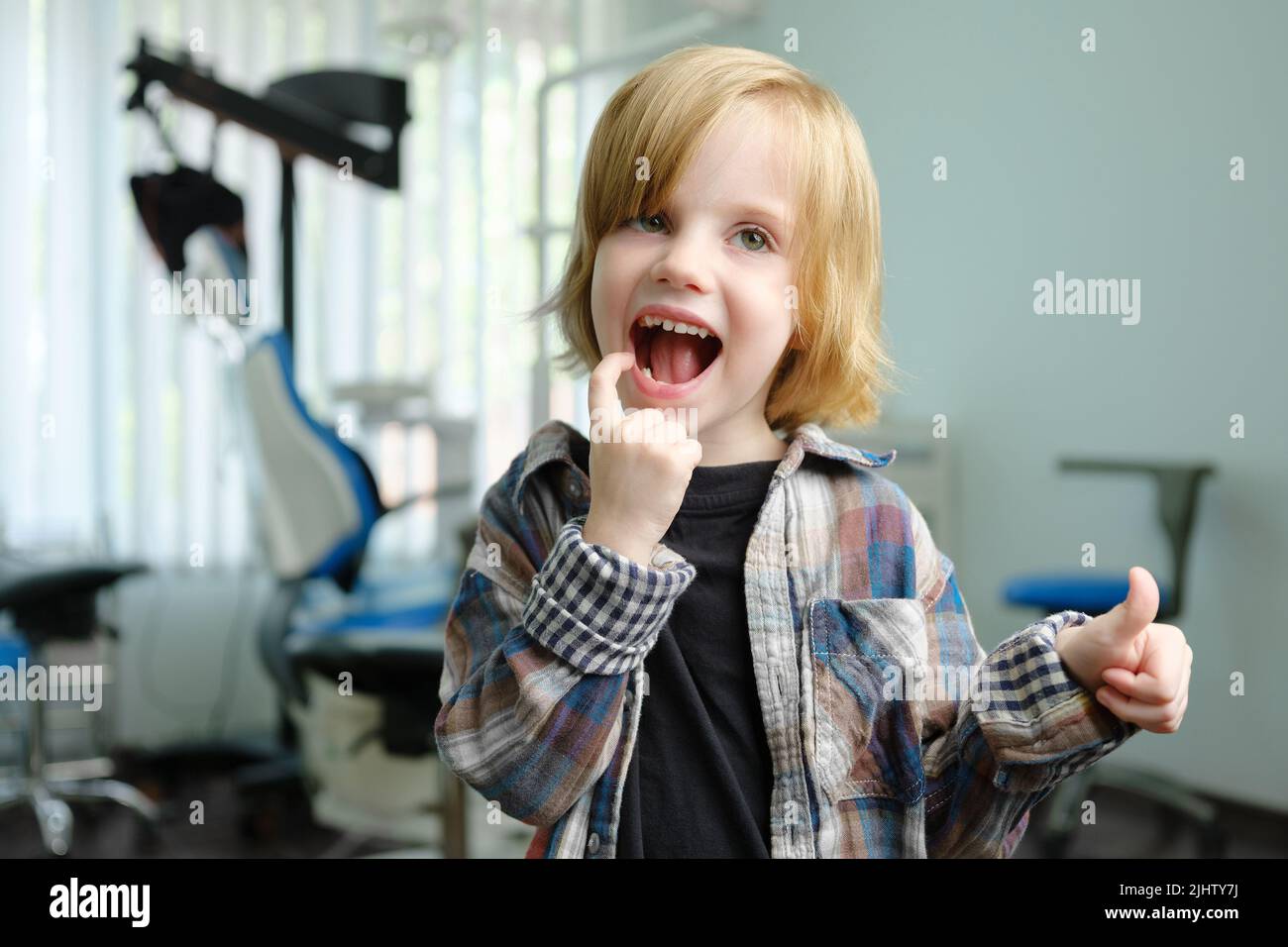 Cute little boy stands in dental clinic cabinet and getting ready for ...
