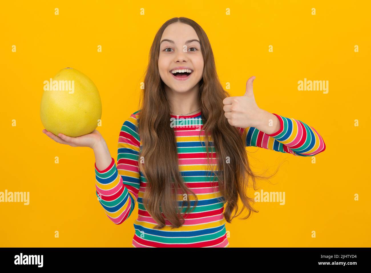 Teenager child girl hold citrus fruit pummelo or pomelo full of vitamin ...