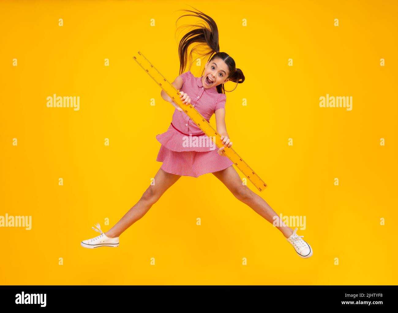 Amazed teenager. Back to school. School girl hold ruler measuring ...