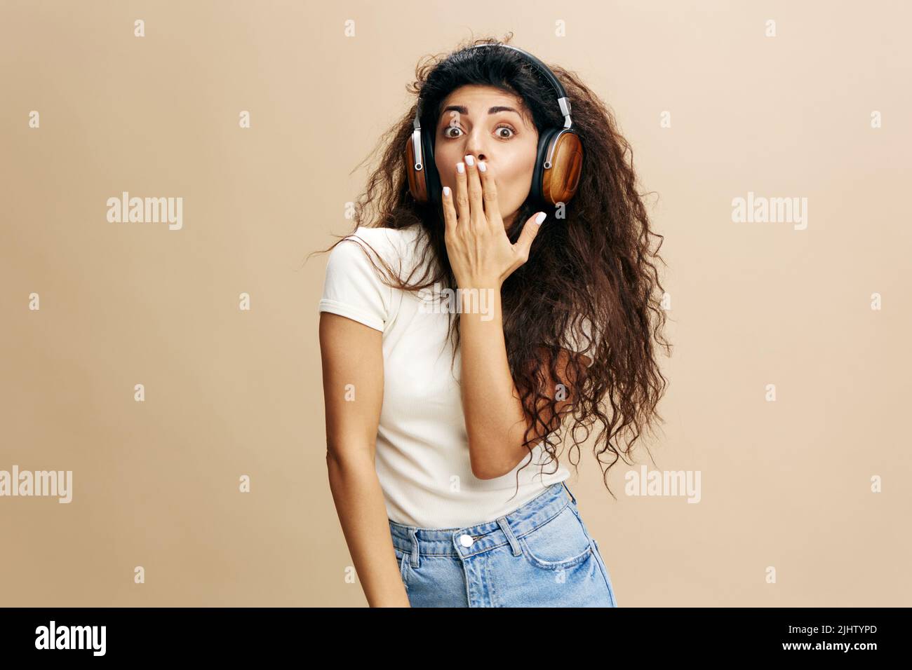 Surprised confused young arab lady covers her mouth with hand, holding ...
