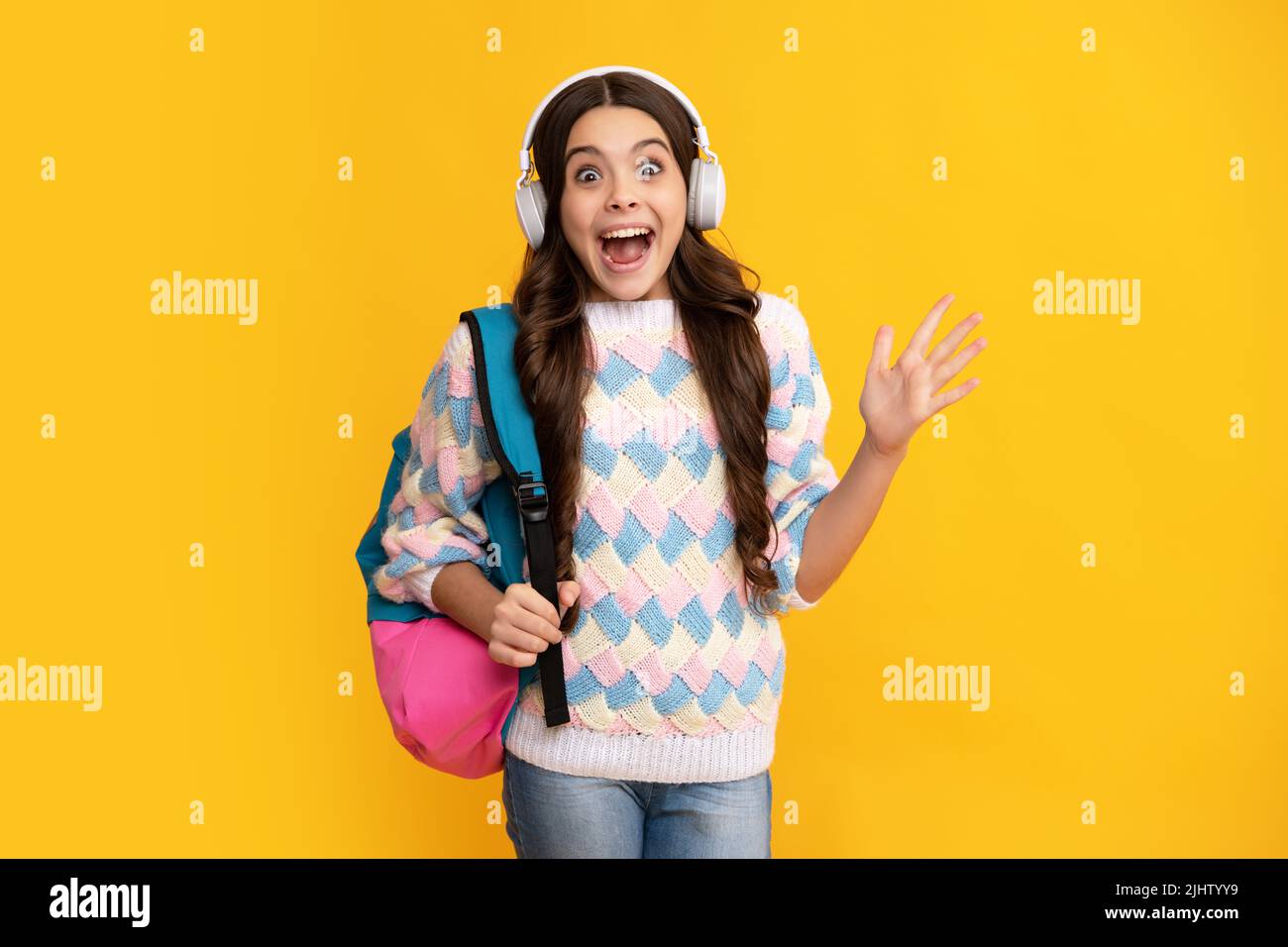 Excited face. School girl, teenager student in headphones on yellow ...