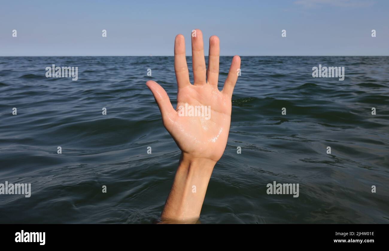 hand with five fingers sticking out of the sea surface that looks ...
