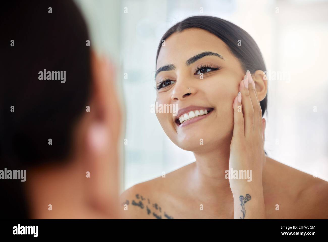 I cant stop touching my face. a young woman doing her skincare routine ...