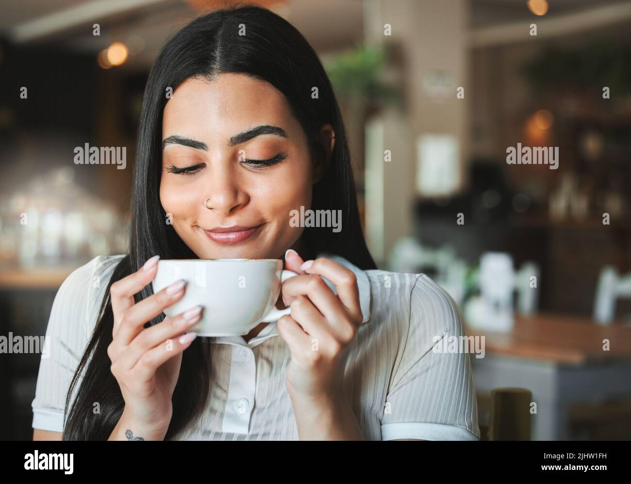 The perfect brew. a young woman enjoying a cup of coffee in a cafe ...