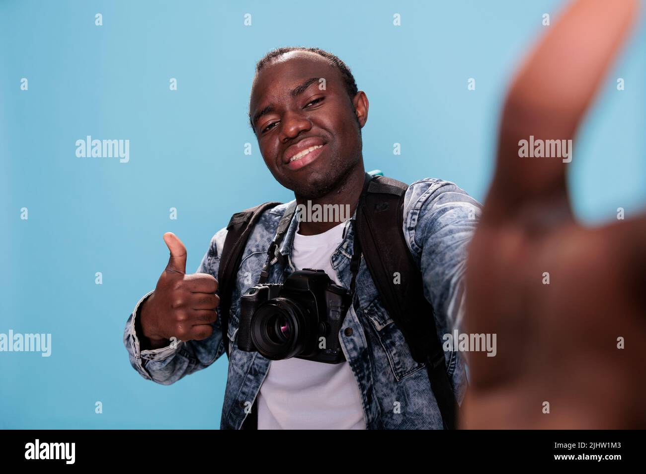 Photography enthusiast giving approve hand gesture while taking picture ...
