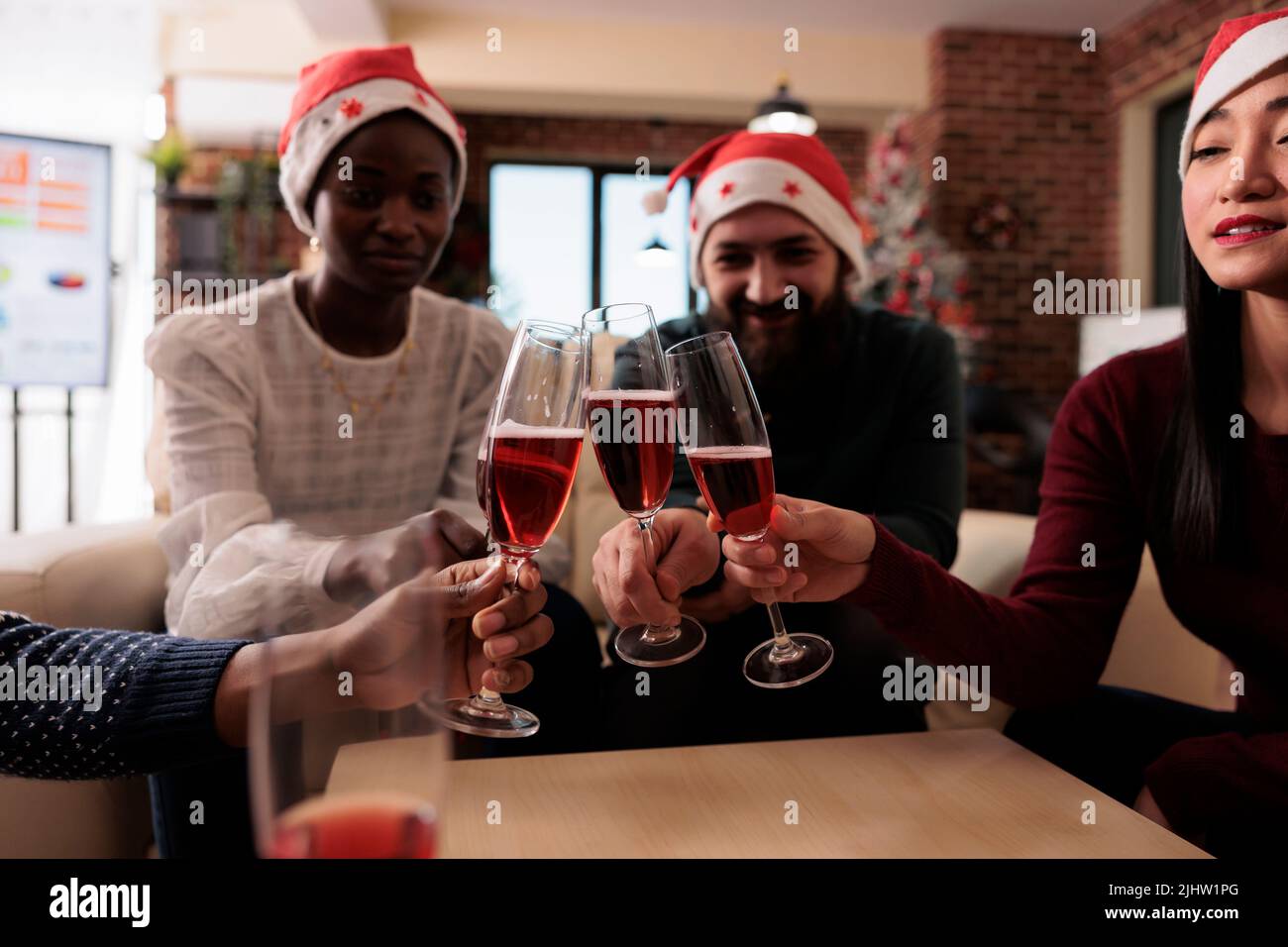 People clinking glasses of wine at xmas office party, giving toast with ...