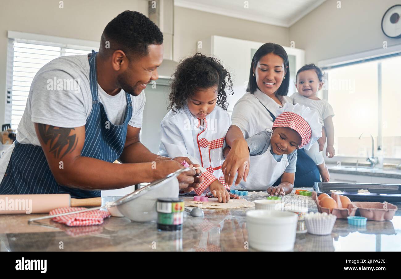 Were making our favourite recipe. a couple baking at home with their three children Stock Photo ...