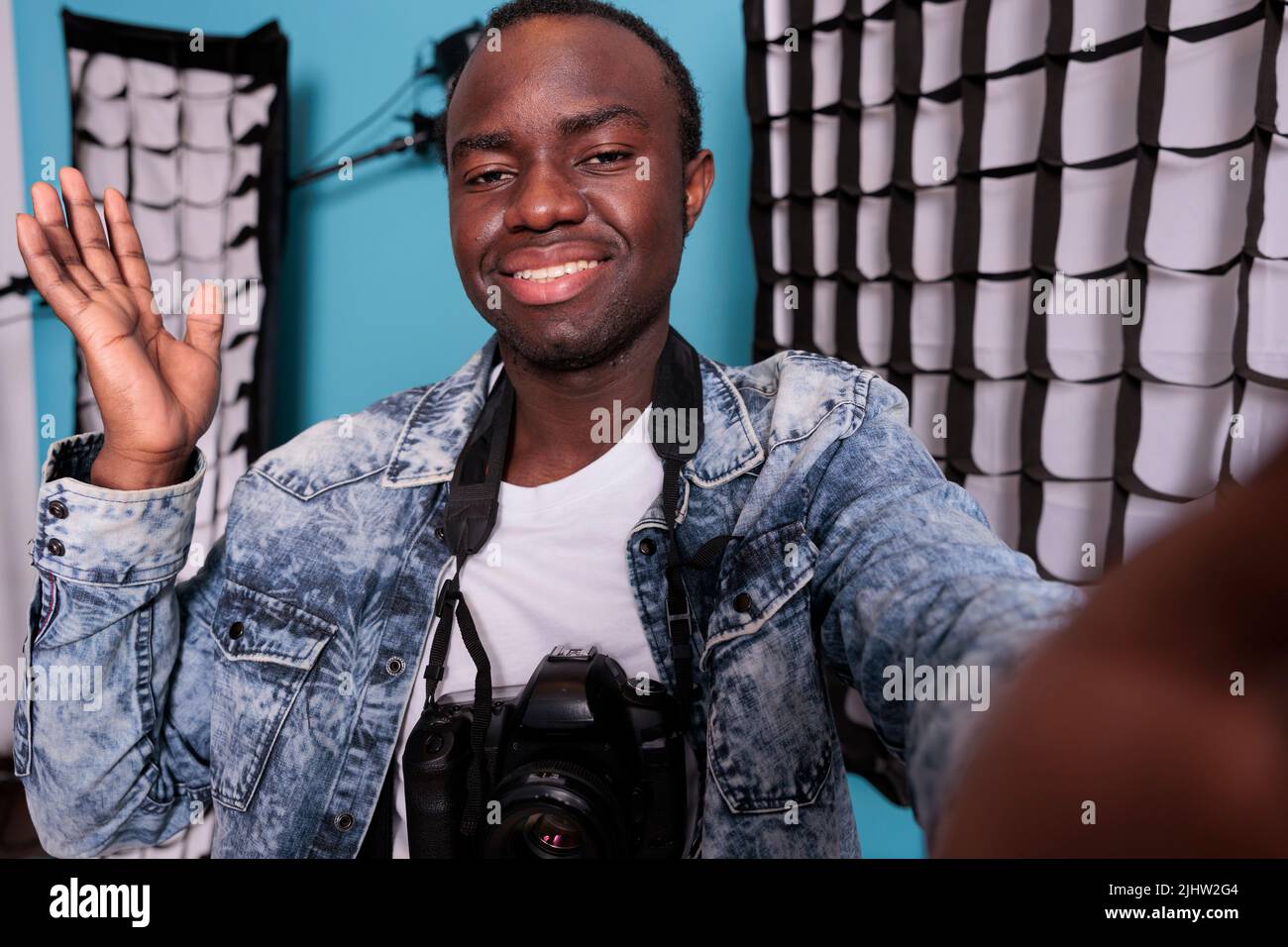 Photography enthusiast taking picture of himself beside softboxes and ...