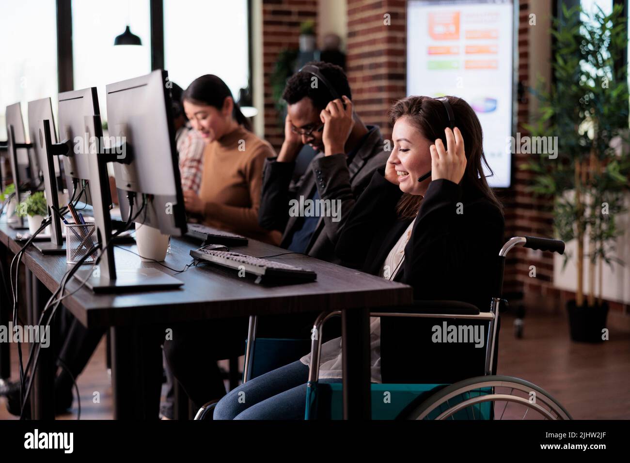 Client helpline operator with chronic health condition using wheelchair ...