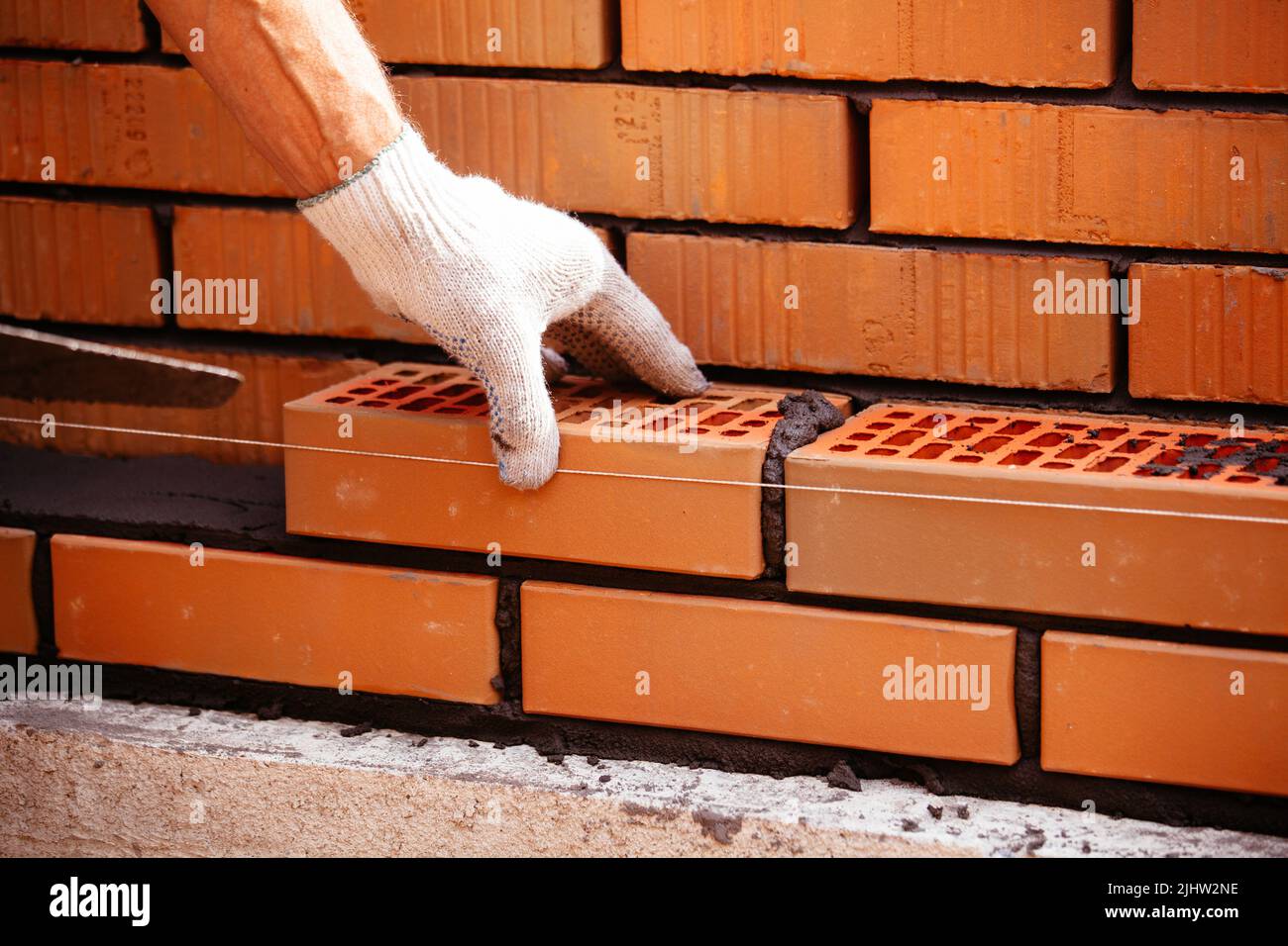 Builder laying bricks on construction site Stock Photo - Alamy