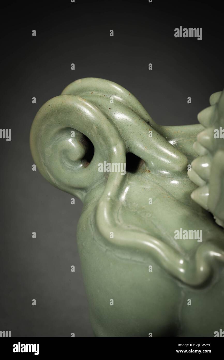 A vertical shot of a part of a traditional Chinese ceramic lion statue ...