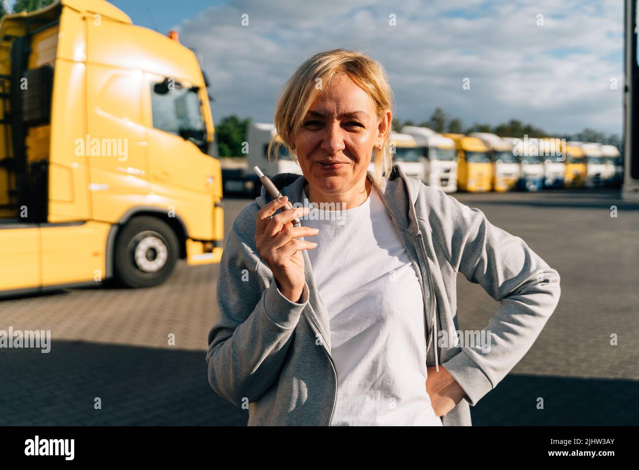 Caucasian mature woman in middle age working as a truck driver. Smoking ...