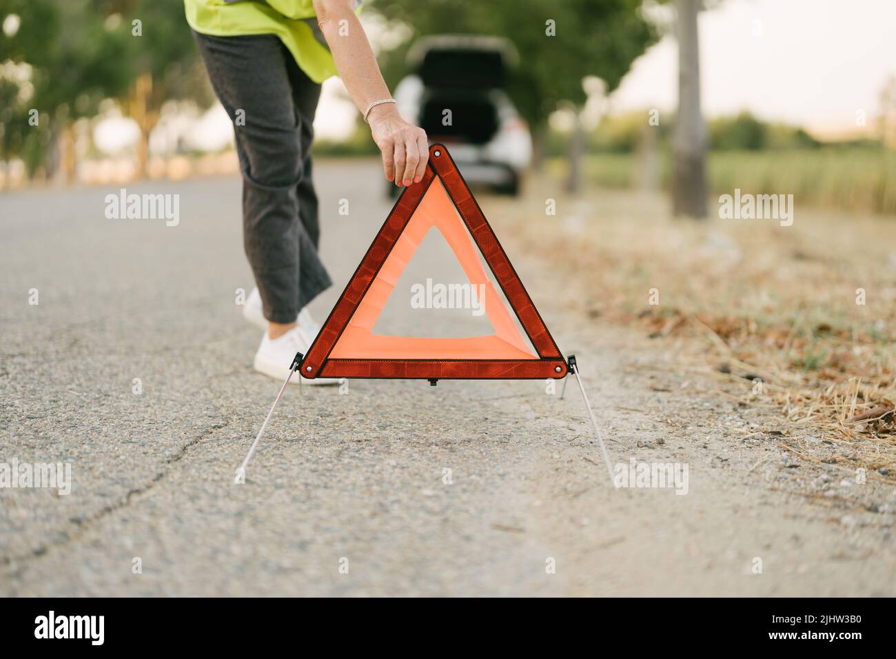 woman placing the emergency triangle on the road Stock Photo - Alamy