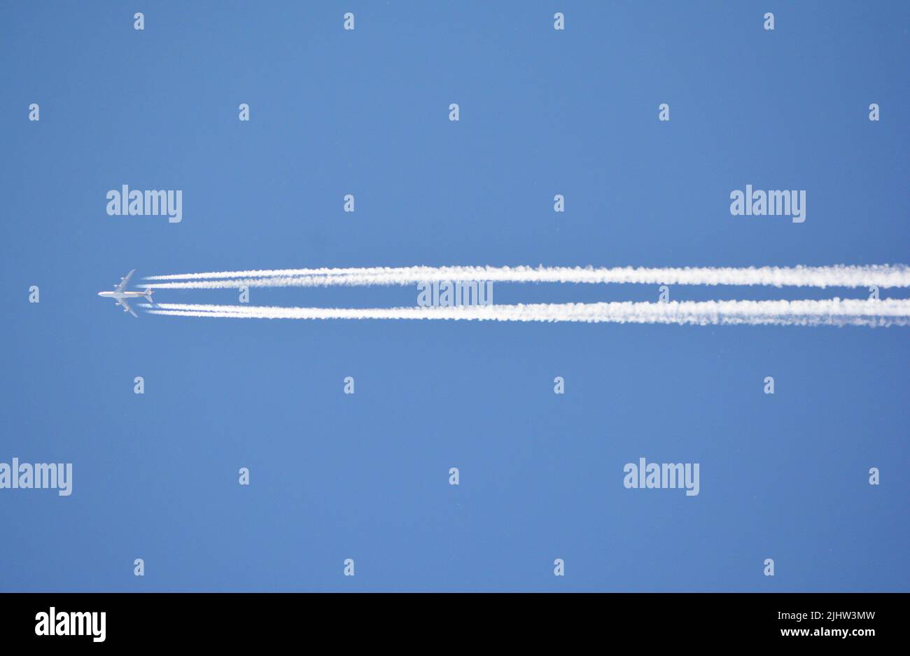 a jet and its trace in a blue sky Stock Photo - Alamy