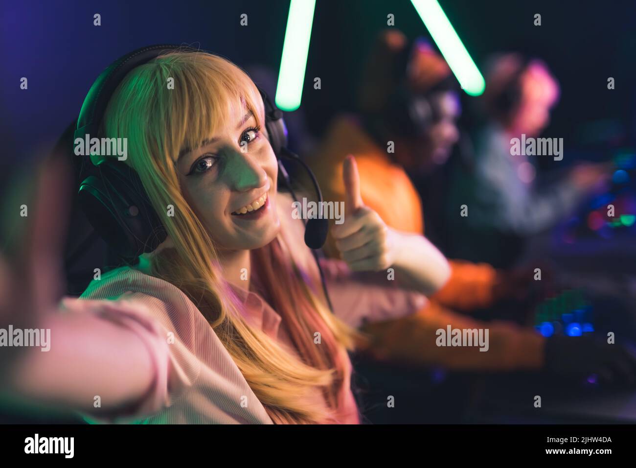 Indoor shot of a blonde cute gamer girl with blonde hair and a fringe ...