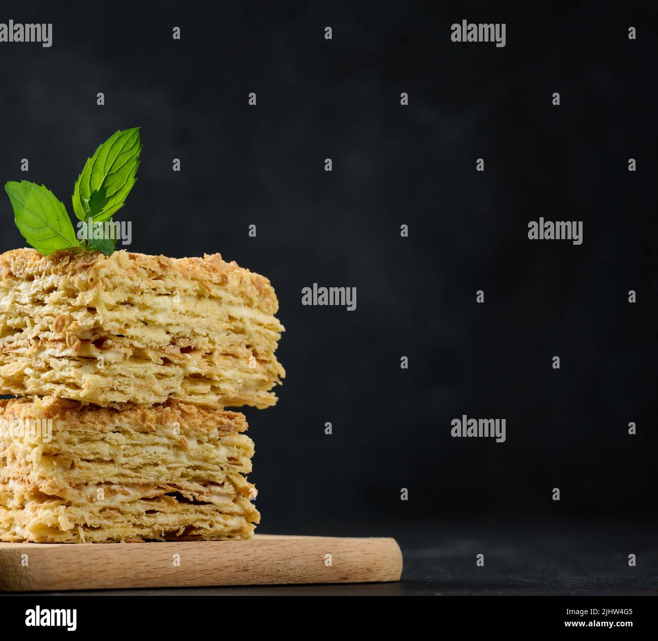 A stack of baked Napoleon pie slices with cream. Puff pastry, delicious ...