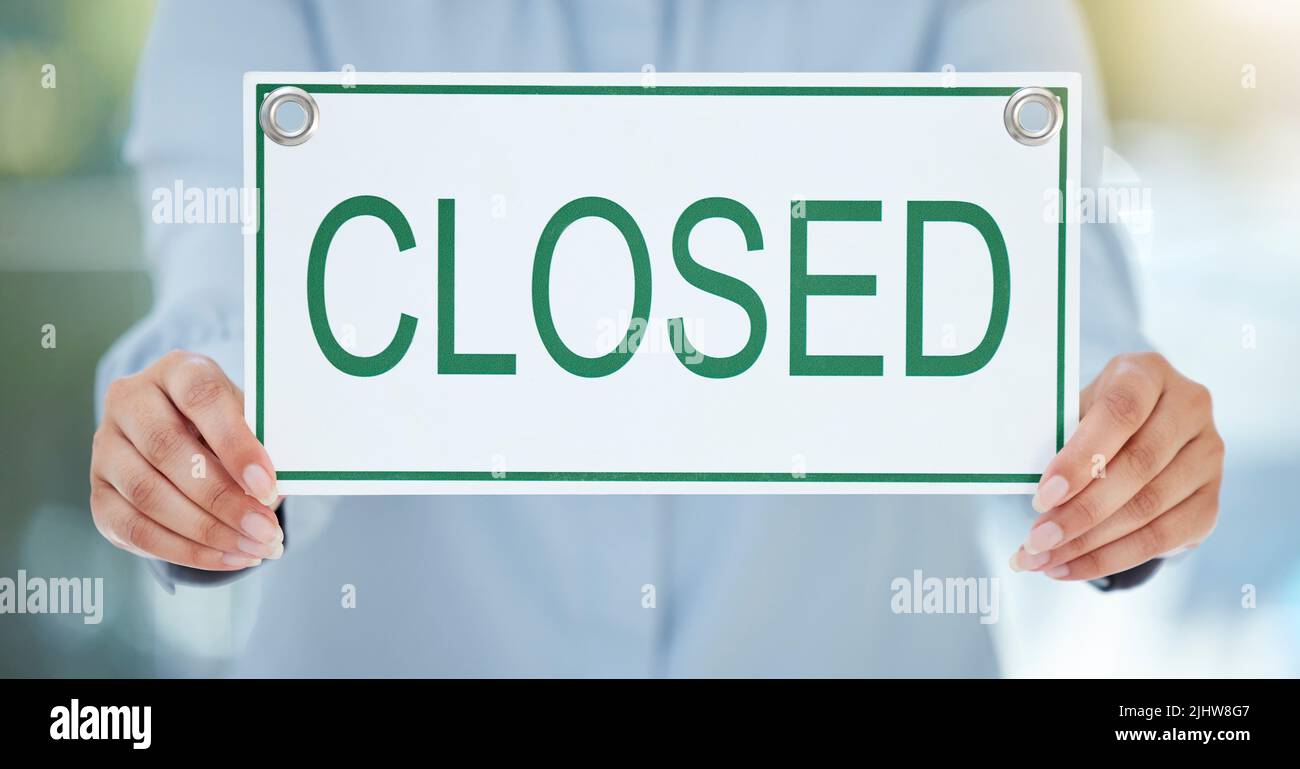 Sorry, were closed. an unrecognizable businesswoman holding up a closed ...
