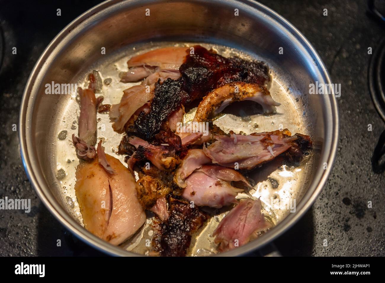 Chicken meat frying in the pan on top of the stove. Salvador, Bahia ...