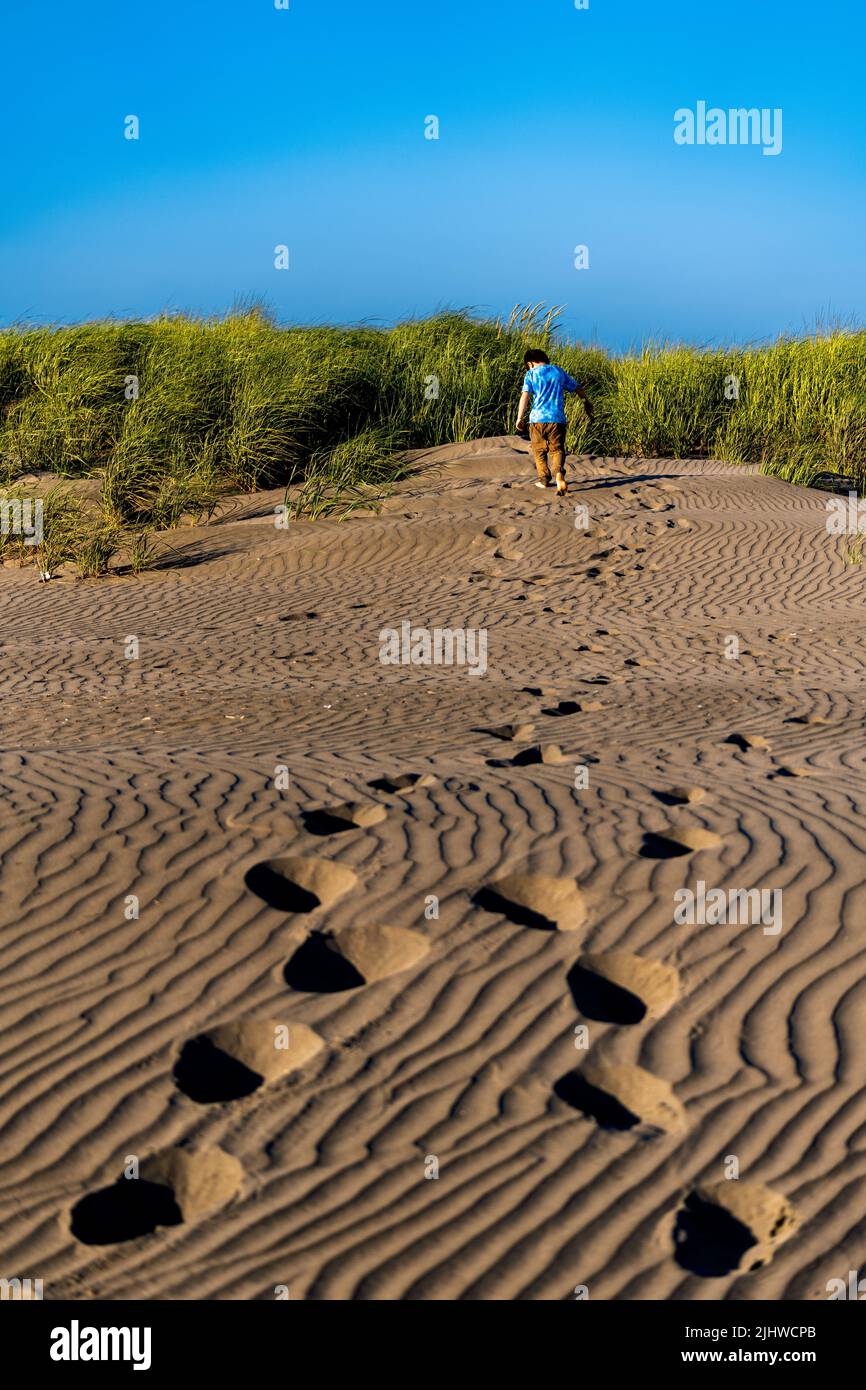 A man walking with footsteps on the beach Stock Photo - Alamy