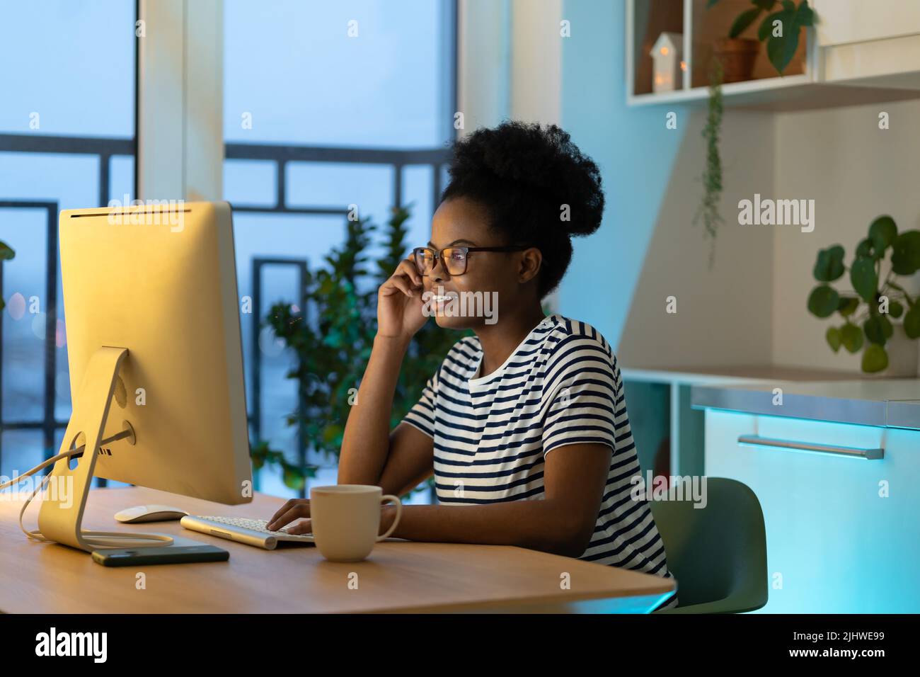 Joyful young african millennial student girl looking at computer screen ...
