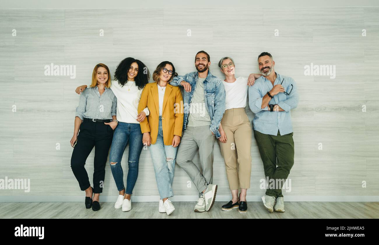 Multicultural businesspeople smiling at the camera while standing ...