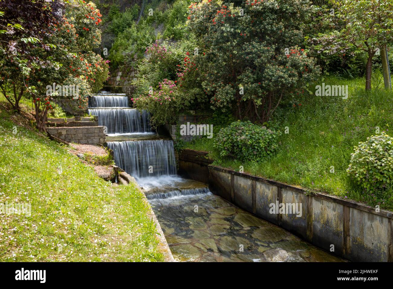Beautiful artificial waterfall with several falls. Water running freely ...