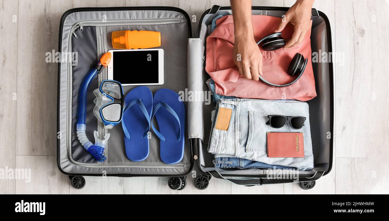 Man packing suitcase at home, top view. Travel concept Stock Photo - Alamy