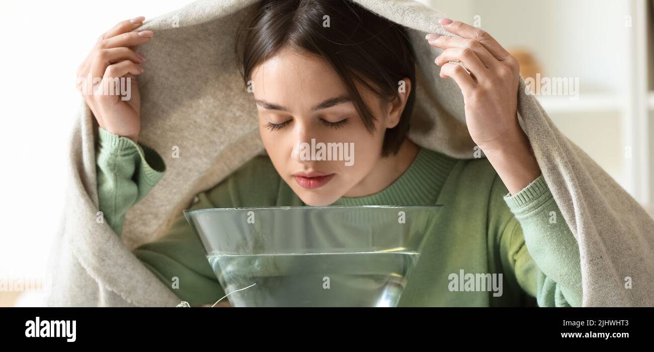 Young woman doing steam inhalation at home to soothe and open nasal ...