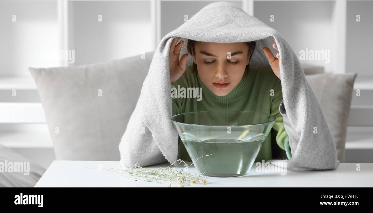 Young woman doing steam inhalation at home to soothe and open nasal ...