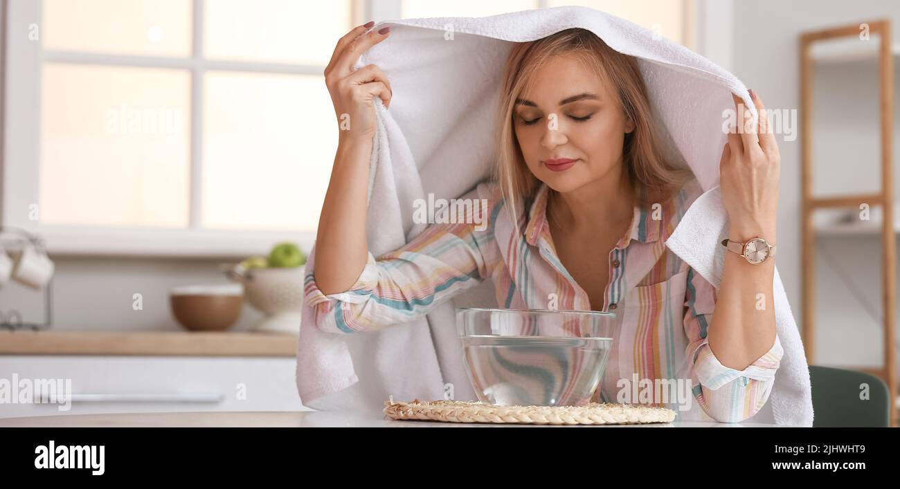 Woman doing steam inhalation at home to soothe and open nasal passages ...
