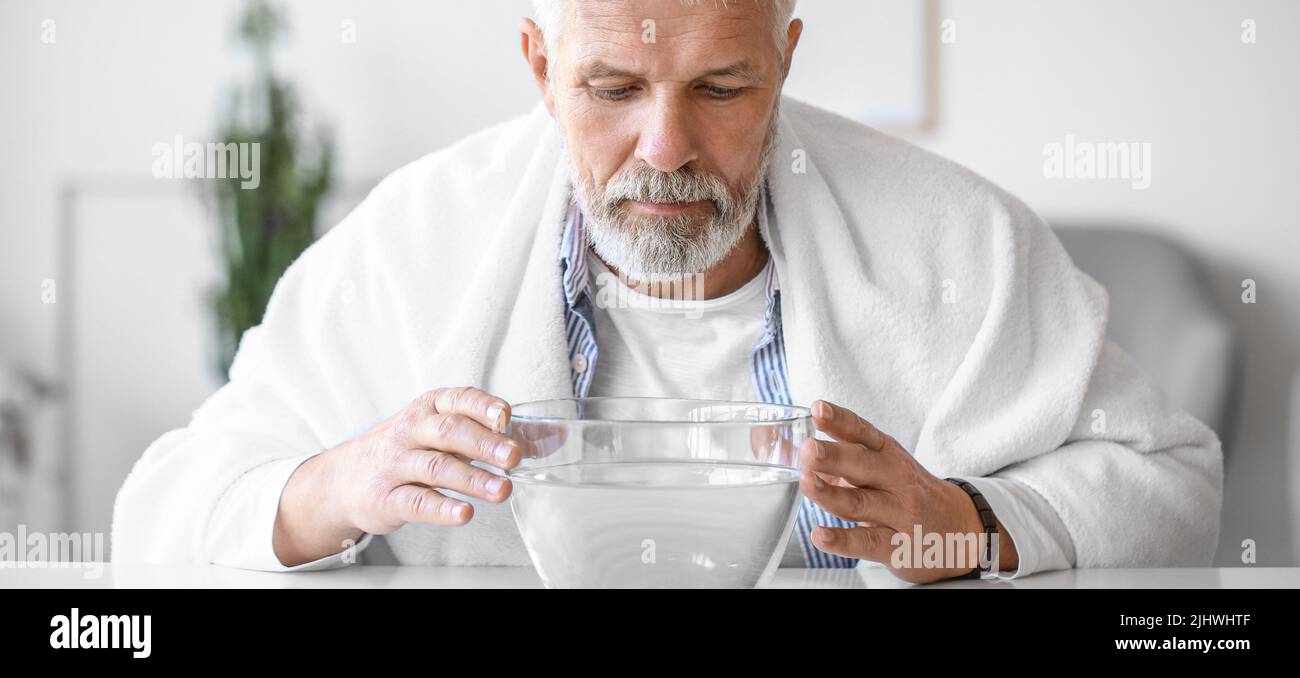 Man doing steam inhalation at home to soothe and open nasal passages ...