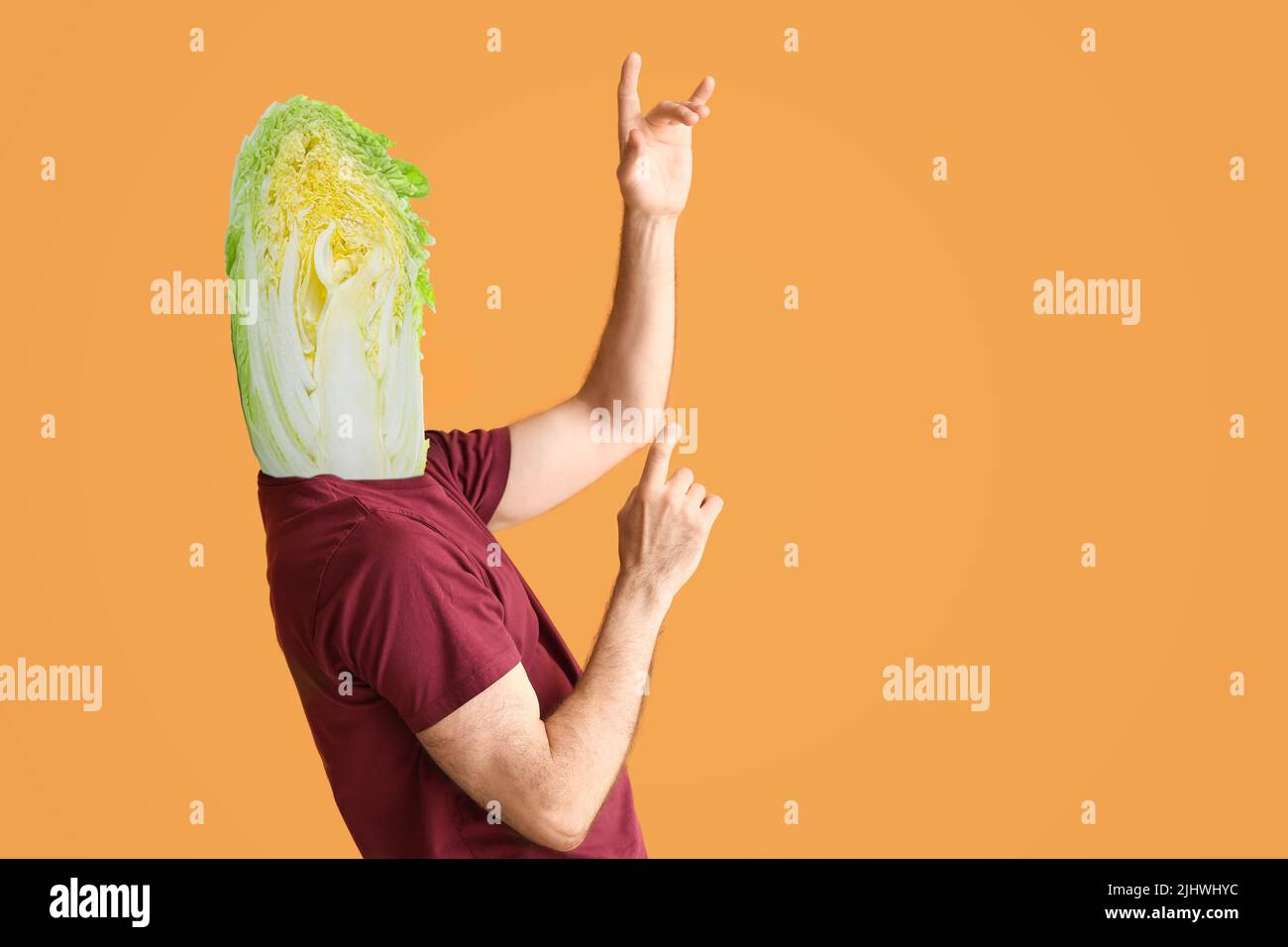 Dancing man with cut Chinese cabbages instead of his head on orange ...