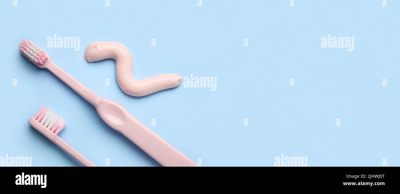 Sample of toothpaste and brushes on blue background with space for text ...