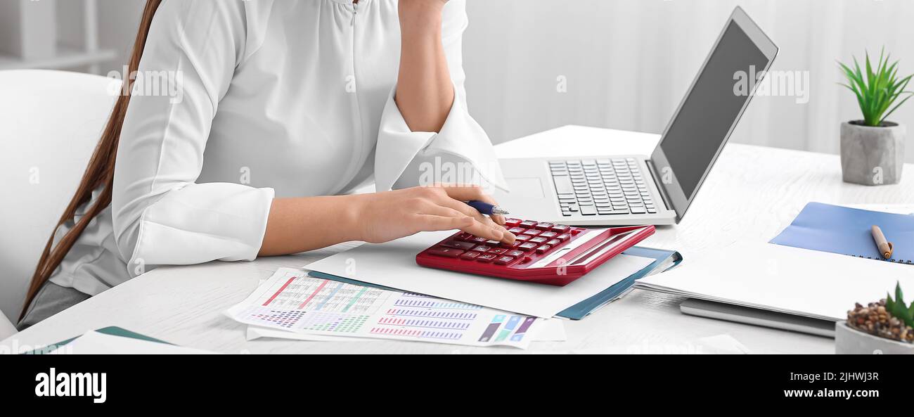 Female accountant with calculator working in office Stock Photo - Alamy