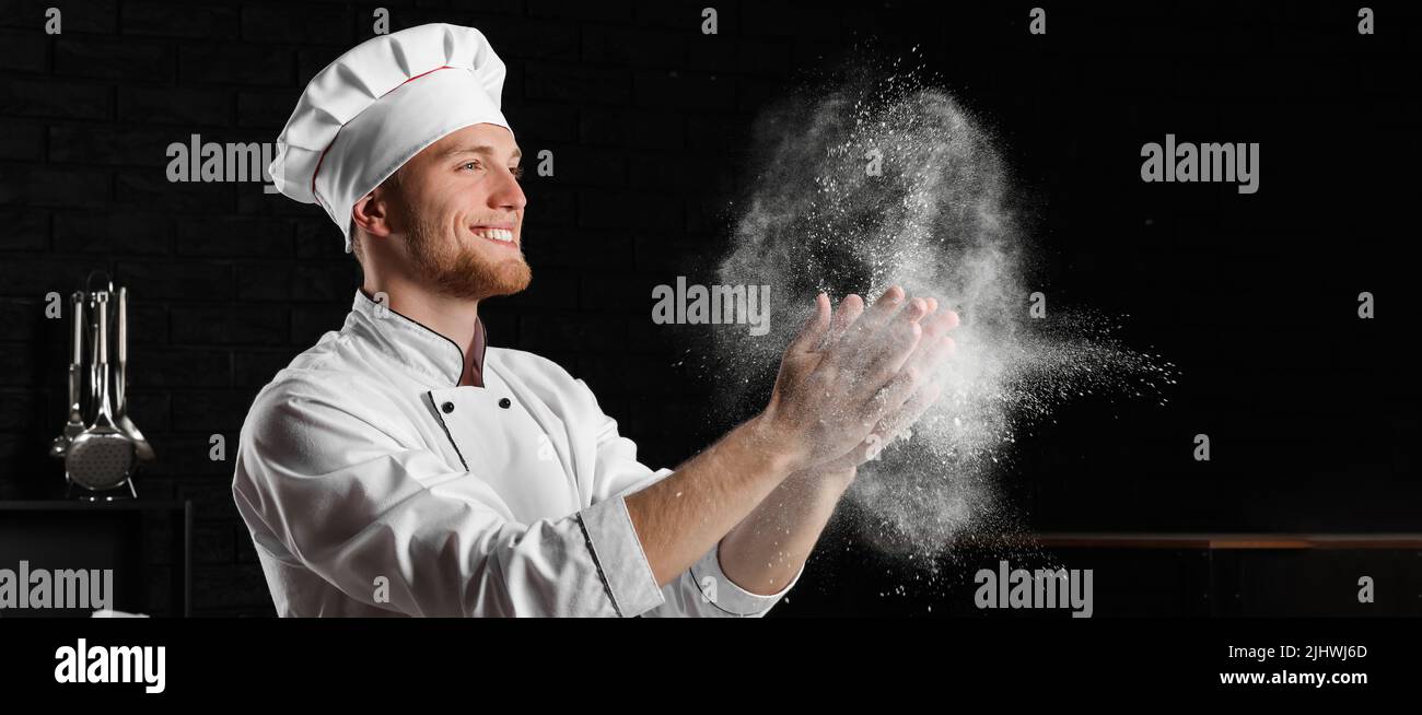 Male chef clapping hands with flour on dark background Stock Photo - Alamy