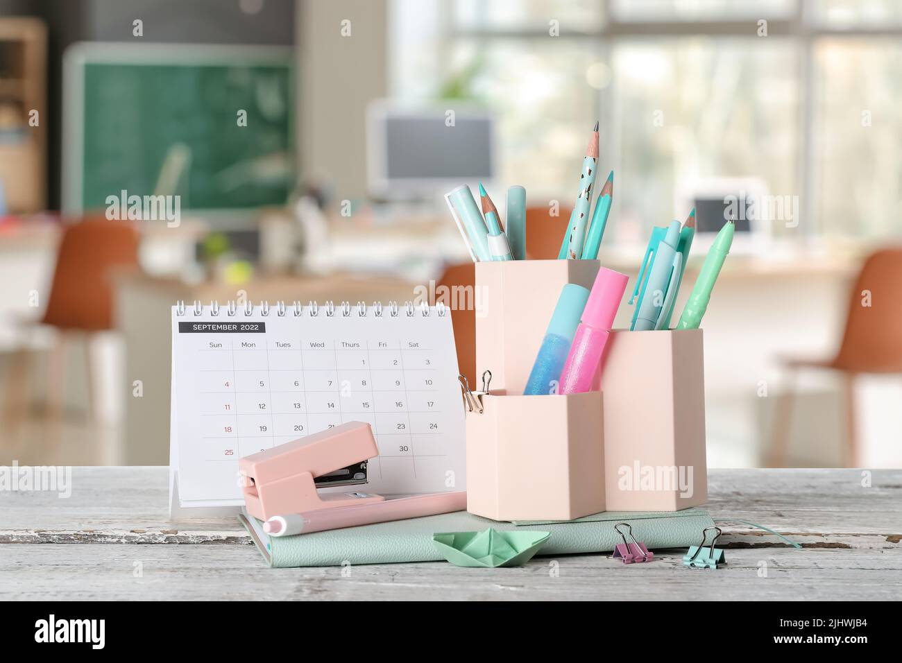 Set of school stationery on table in classroom Stock Photo - Alamy