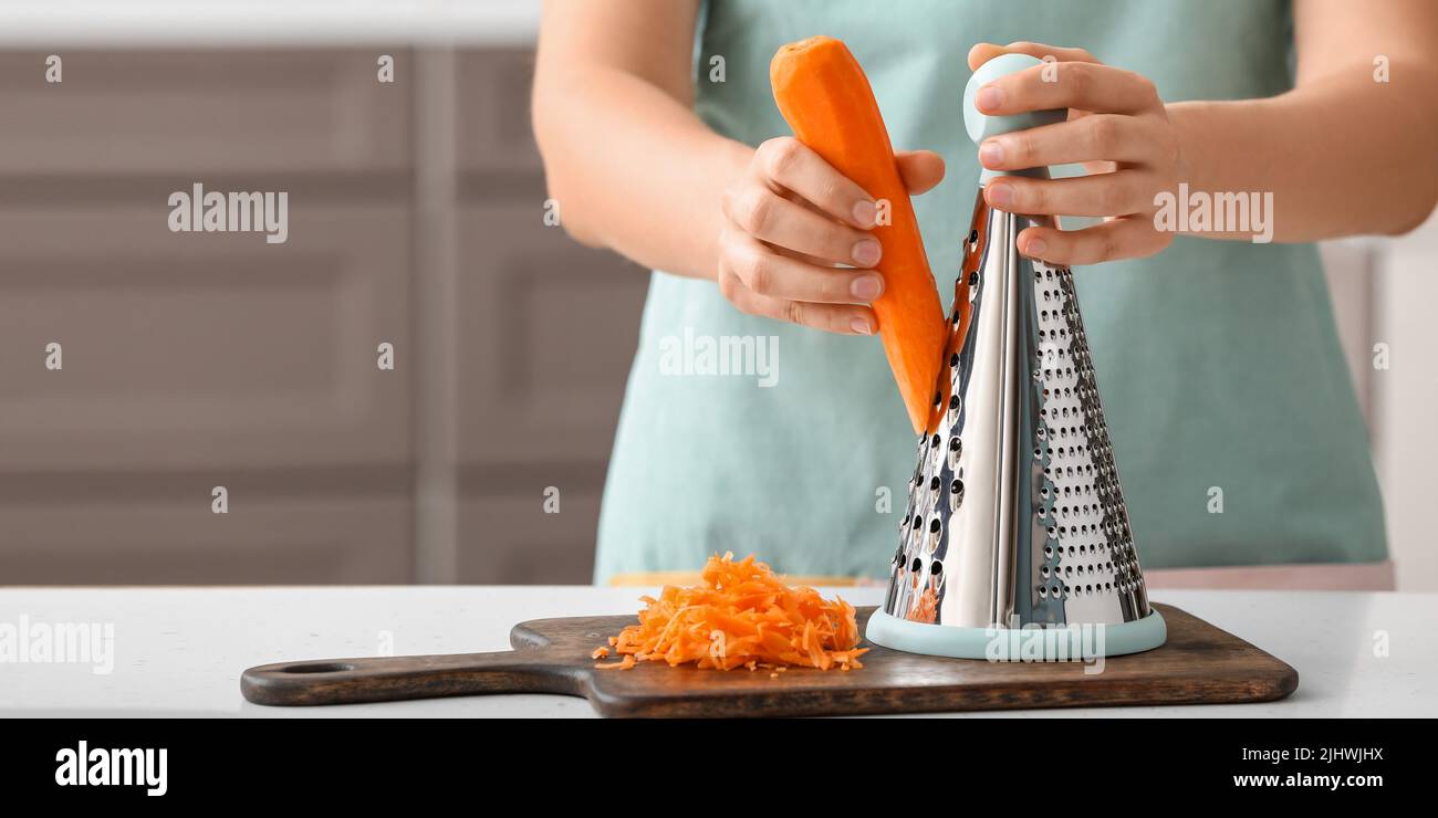 Woman grating fresh carrot in kitchen Stock Photo - Alamy