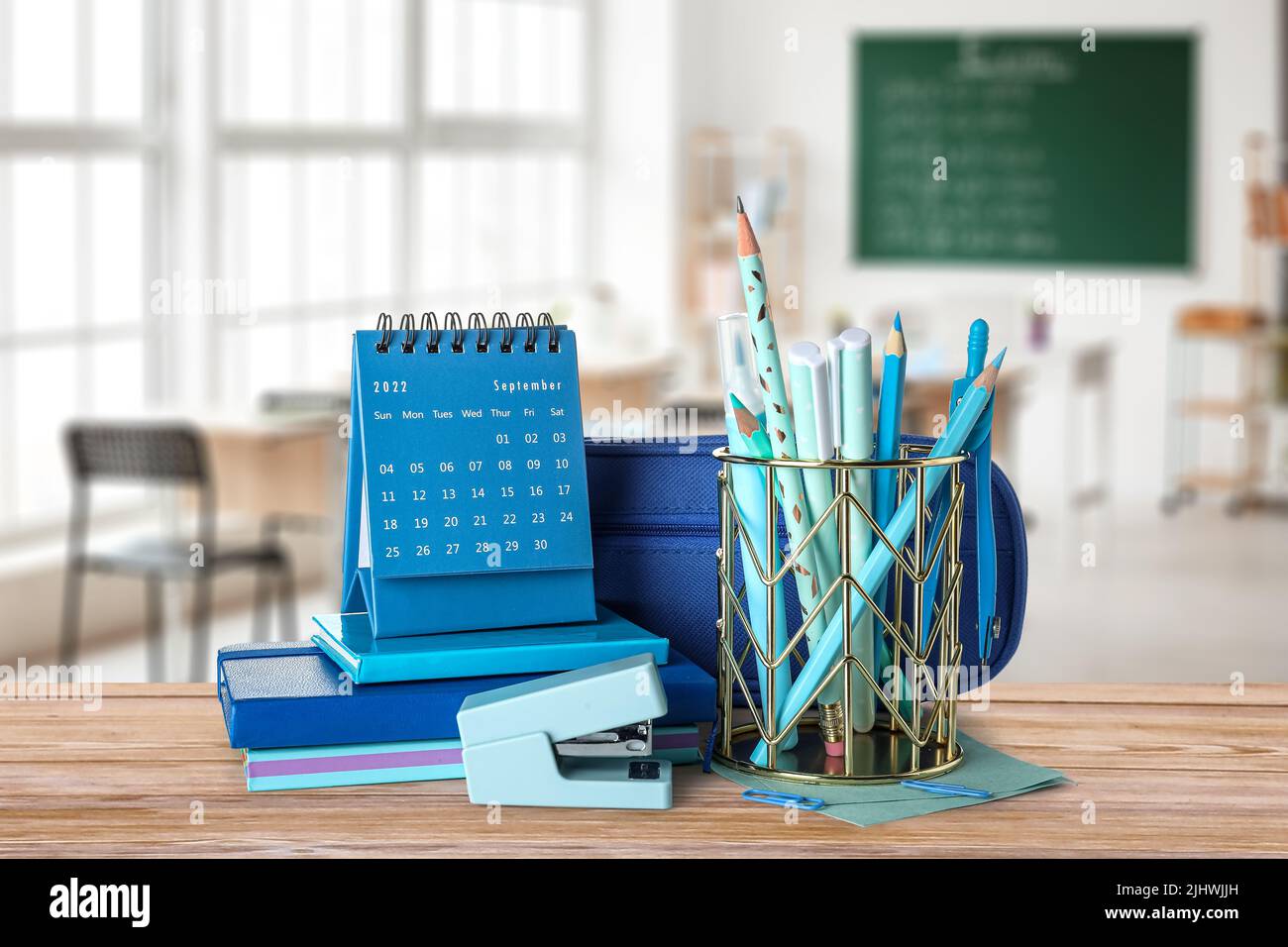 Set of school stationery on table in classroom Stock Photo - Alamy
