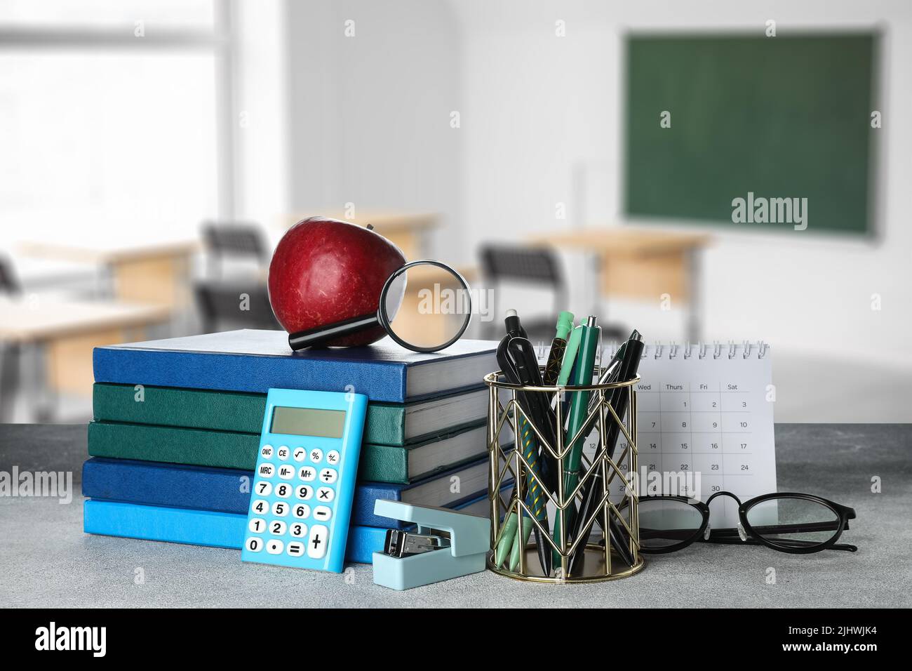 Set of school stationery and apple on table in classroom Stock Photo ...