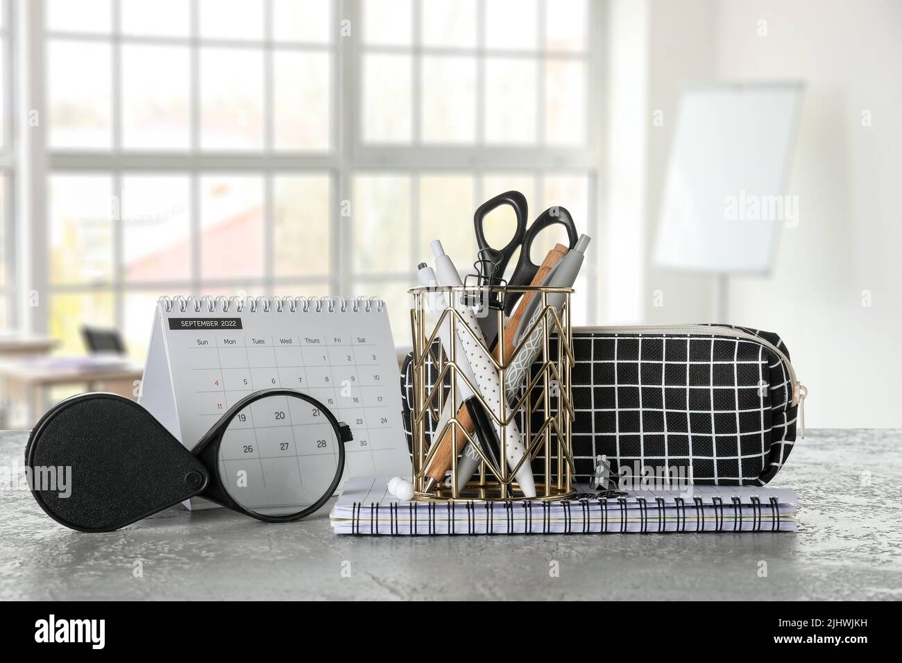 Set of school stationery on table in classroom Stock Photo - Alamy