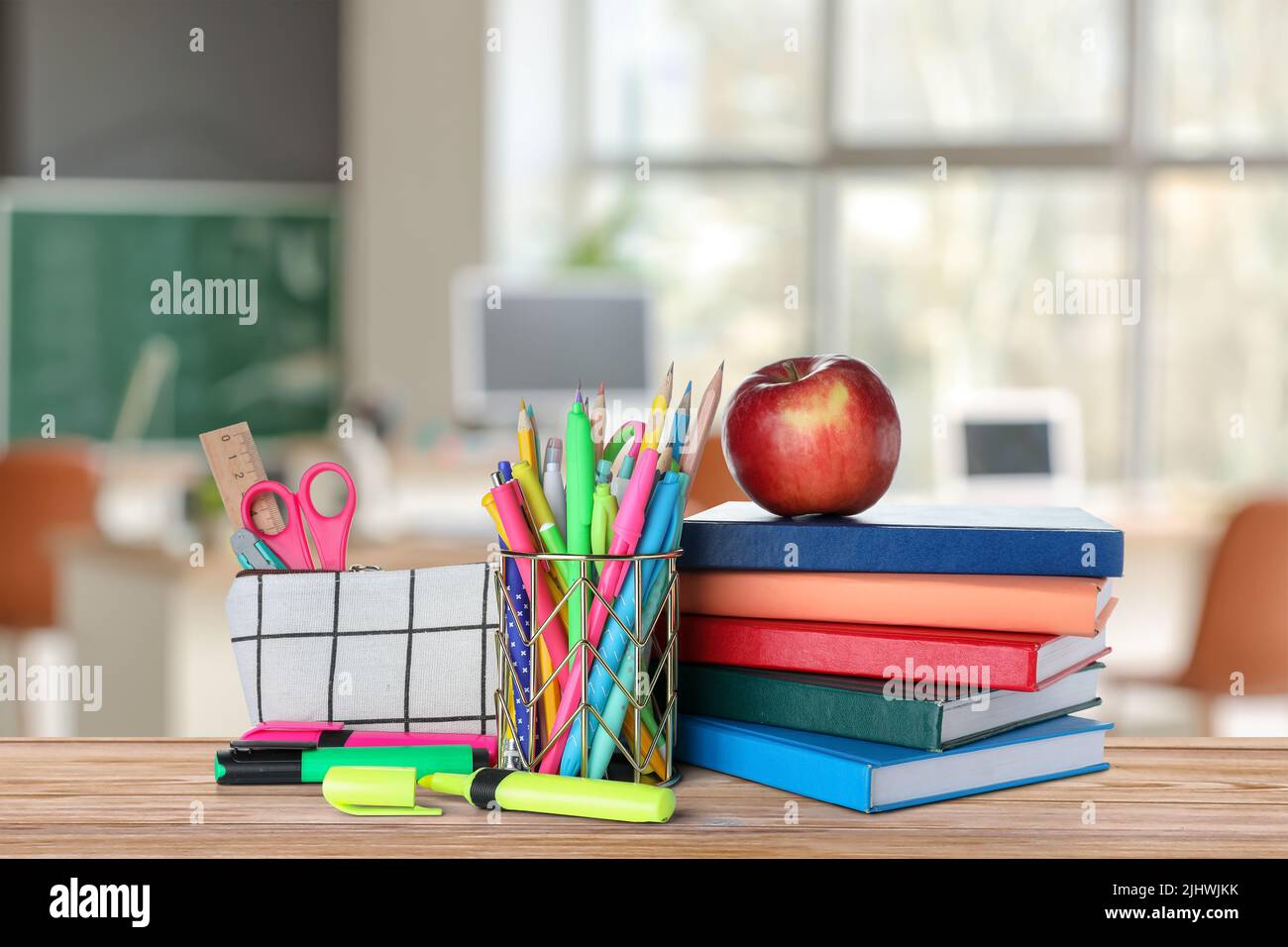 Set of school stationery and apple on table in classroom Stock Photo ...