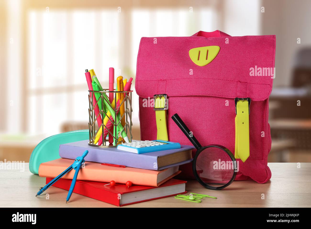 Set of school stationery and backpack on table in classroom Stock Photo ...