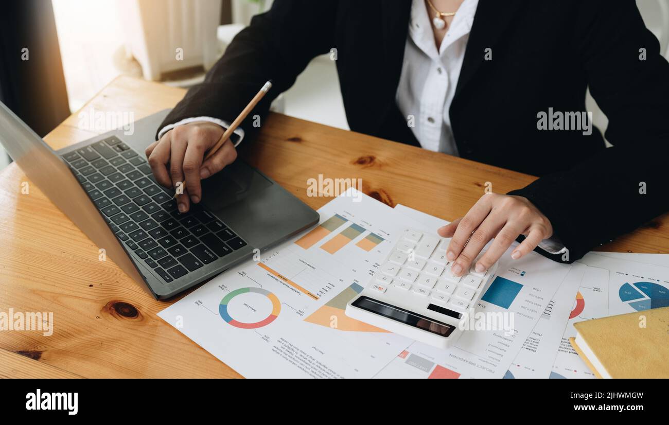 businesswoman accountant working on desk office with using a calculator ...