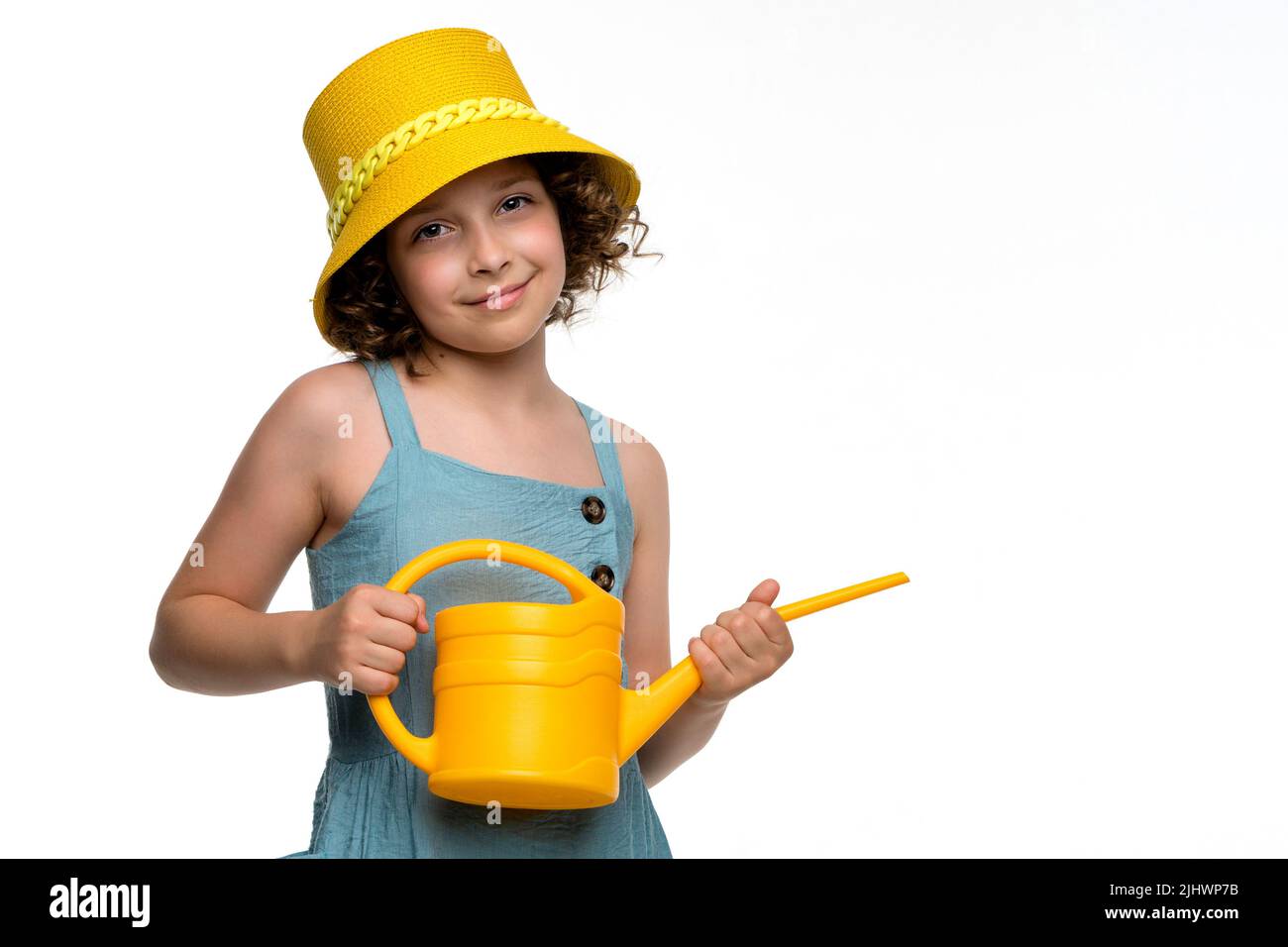 Cute curly short-haired preteen girl in yellow panama hat and blue ...