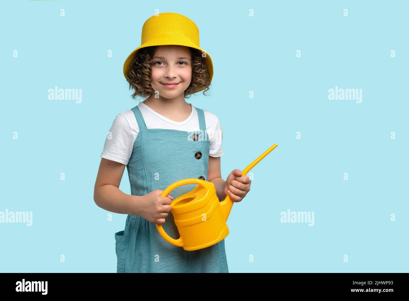 Cute curly short-haired schoolgirl 10-12s in yellow panama hat and blue ...