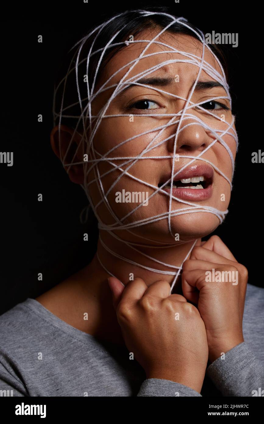 Im a mess. a young woman wrapped in string against a dark background ...