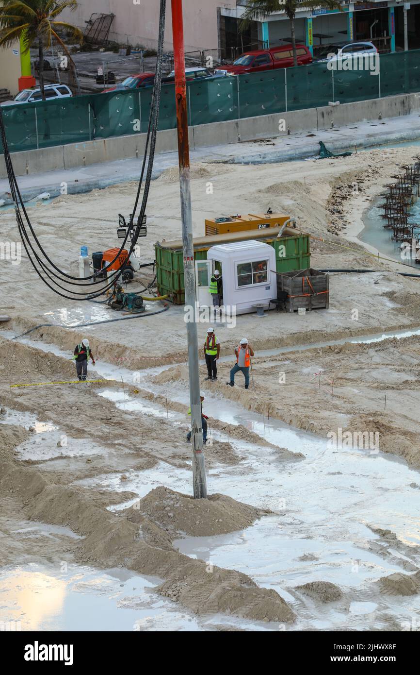 Construction site, worker crew drilling a hole with heavy bore machine ...