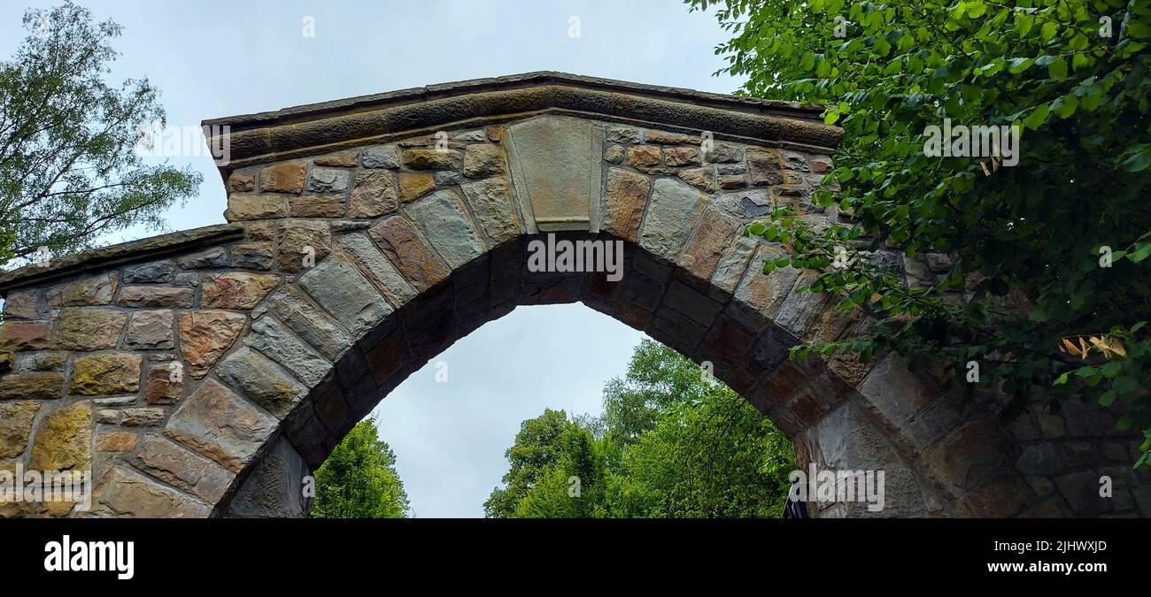 old stone gate surrounded with trees Stock Photo - Alamy